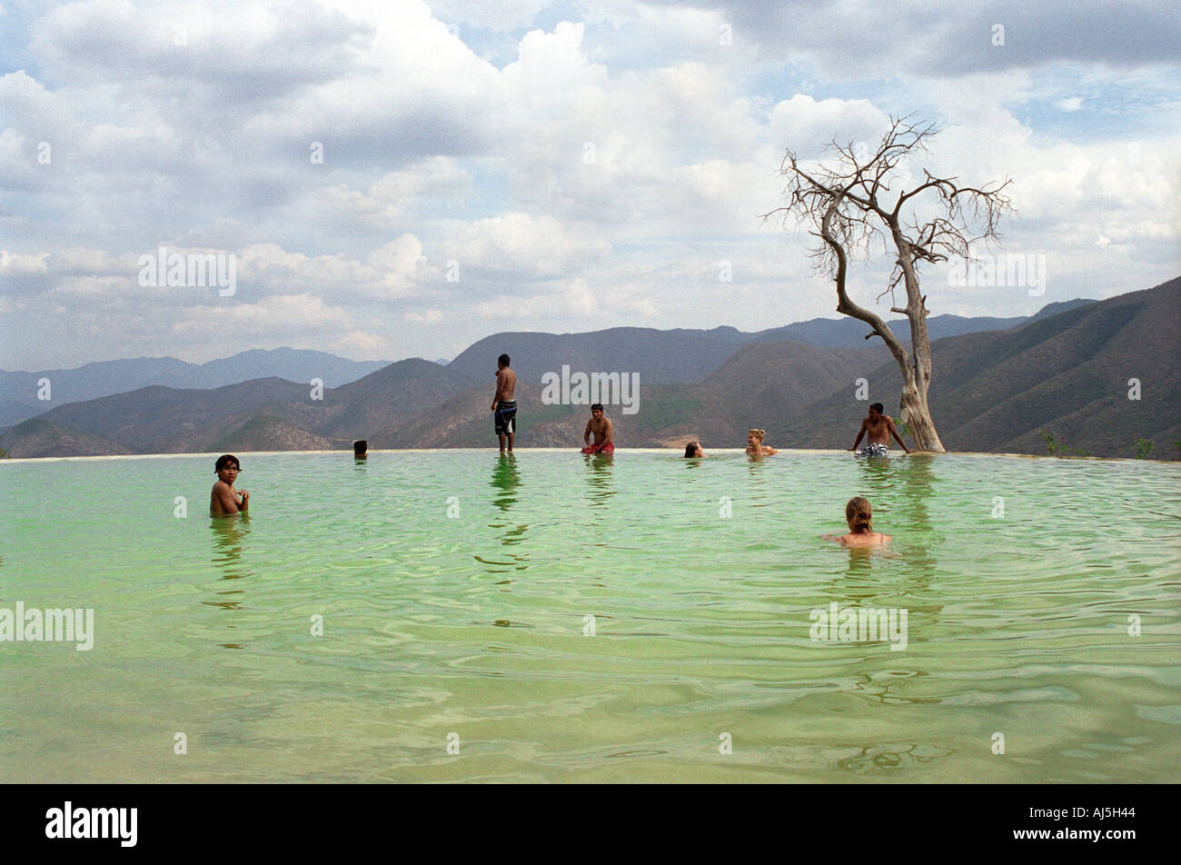 Infinity pool at Hierve el Agua near Oaxaca, Mexico with swimmers. Blue ...