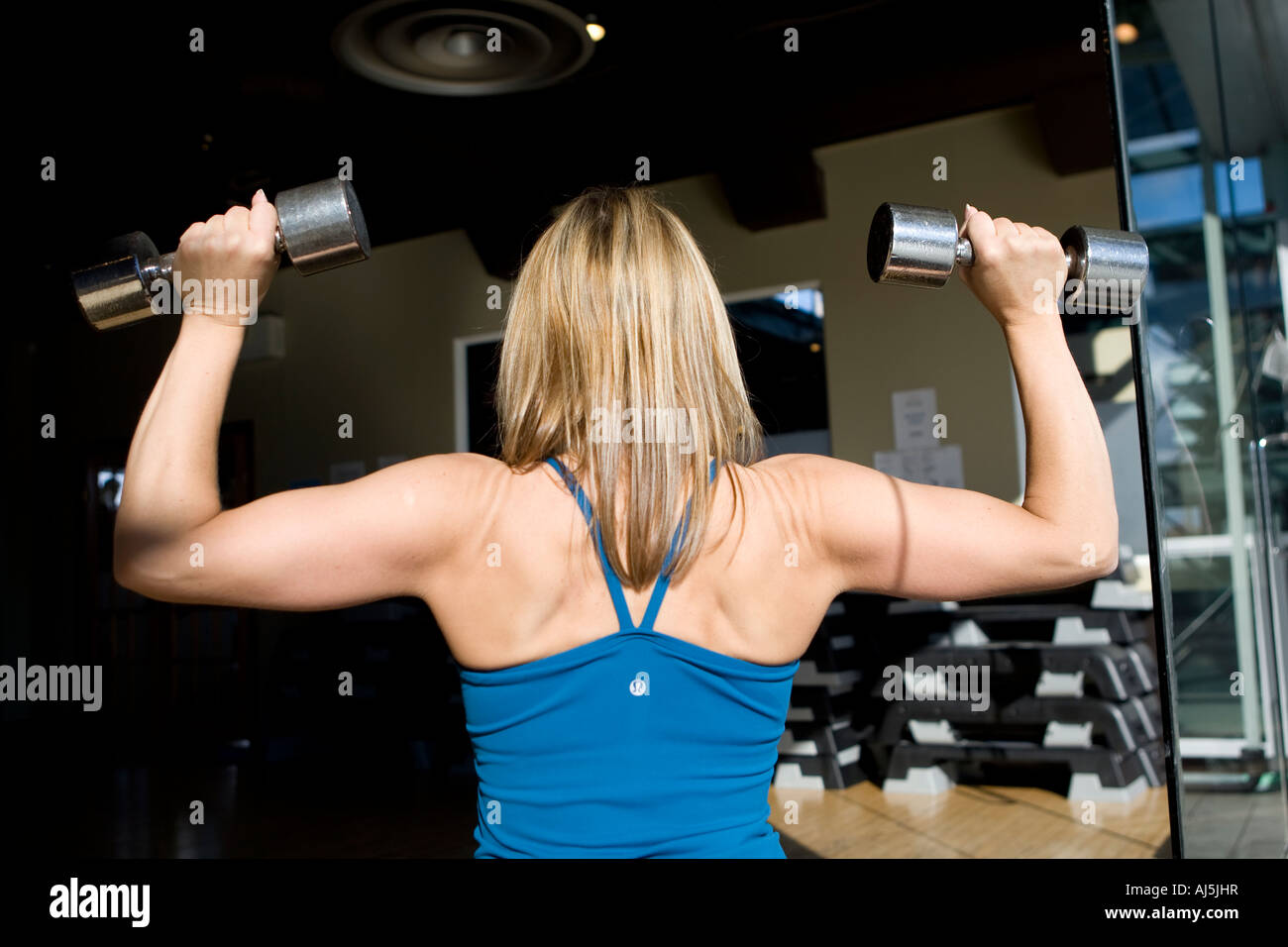 fit fitness girl female exercising in a gym. arm shoulder workout Stock ...