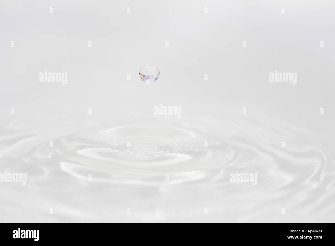 Water drop on white water mirrored surface Stock Photo - Alamy