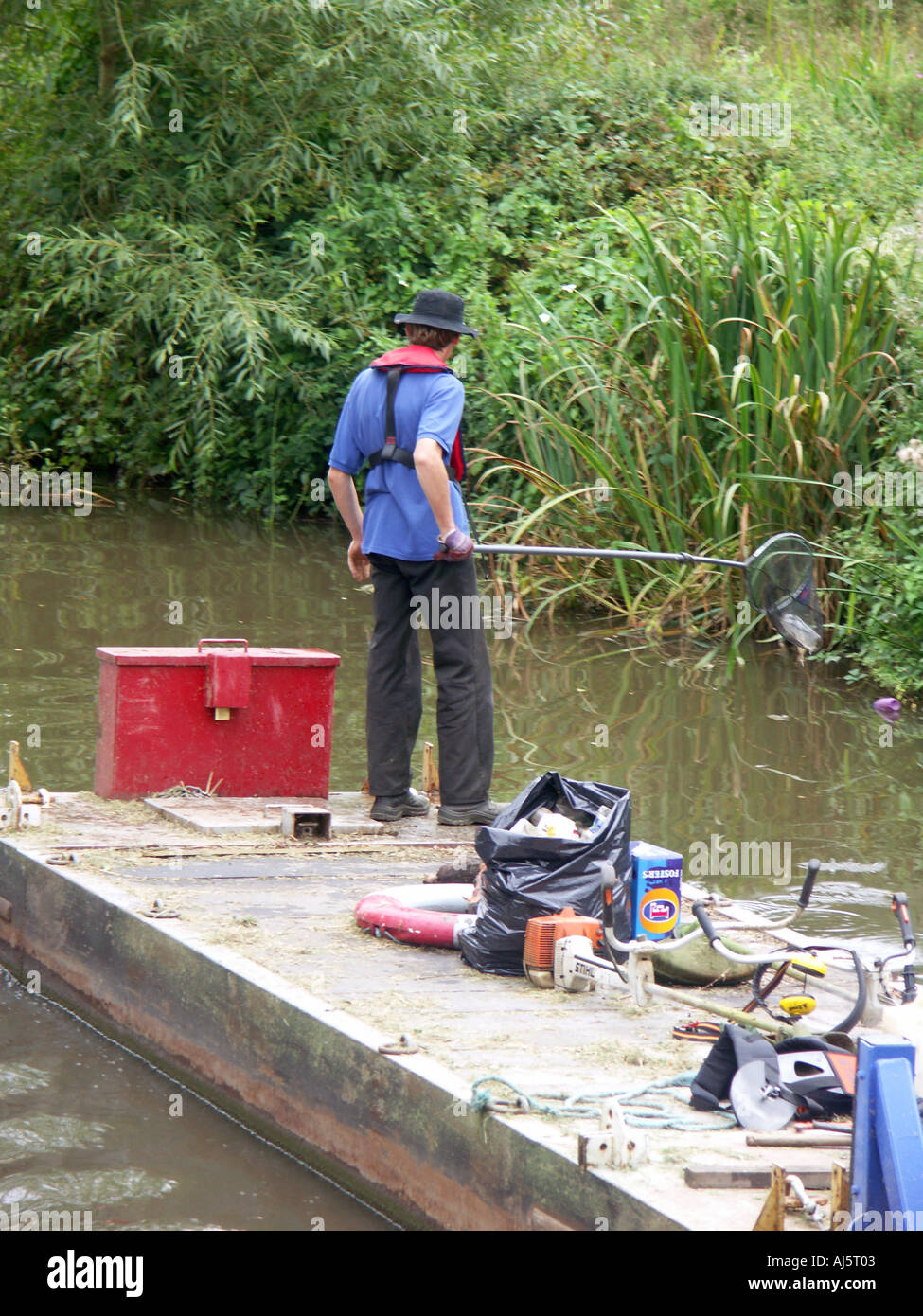 A worker clearing litter from canal Stock Photo - Alamy