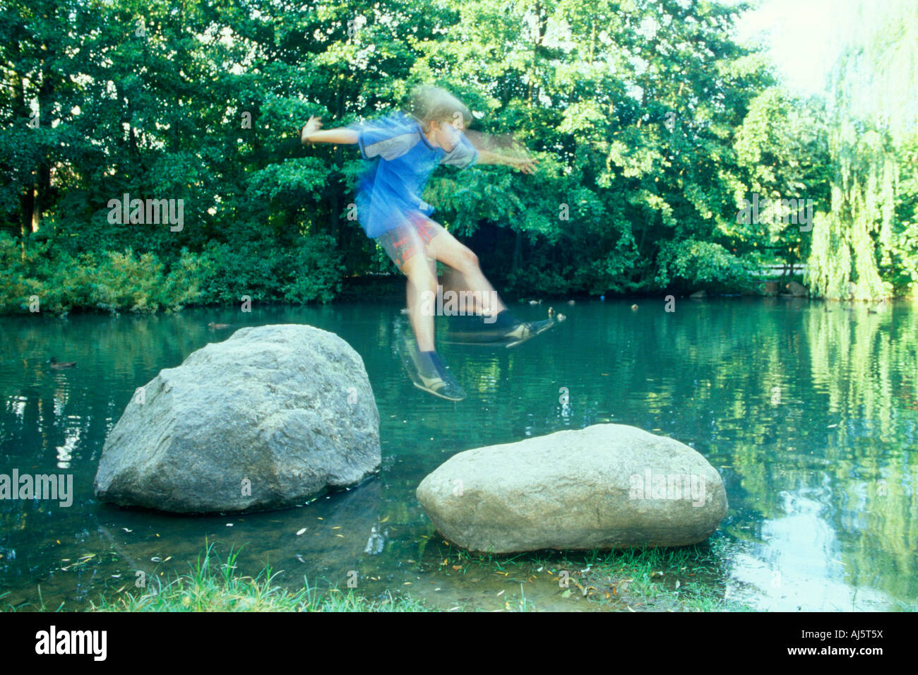 Boy jumping across water hi-res stock photography and images - Alamy