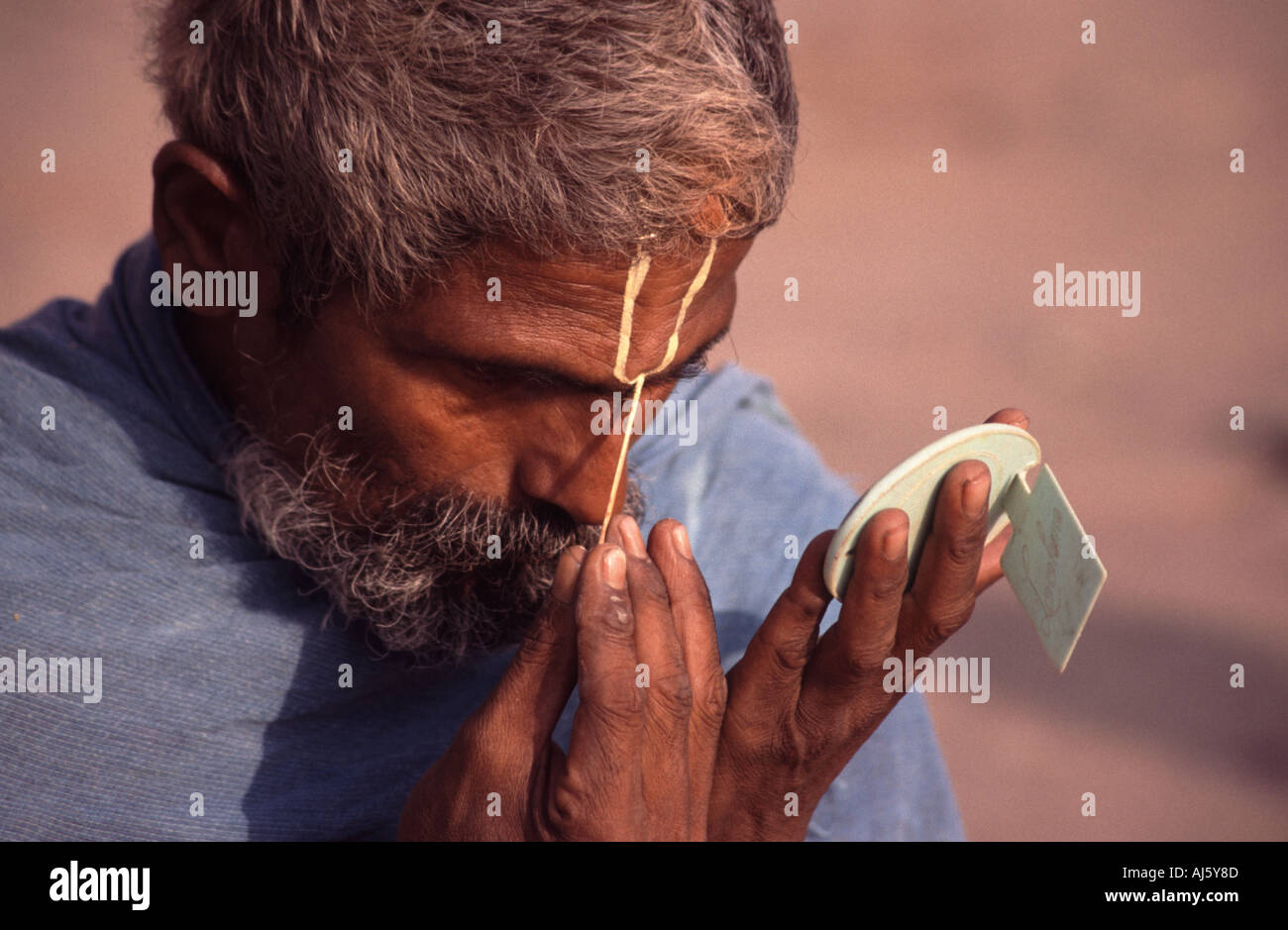a sadhu is painting his face Stock Photo - Alamy