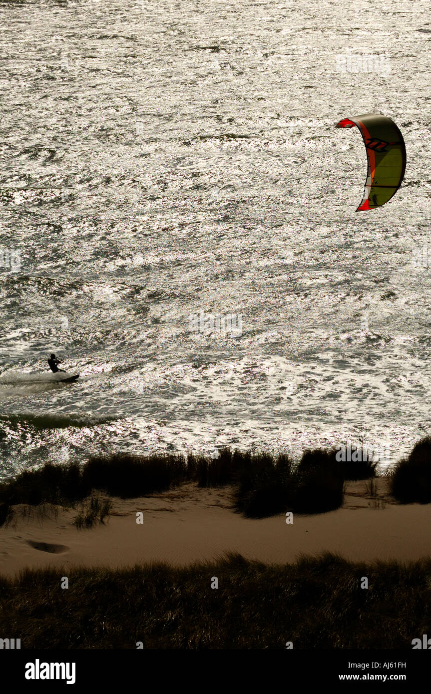 Kite men on a black and dark sea, shot with backlighting from a heli ...