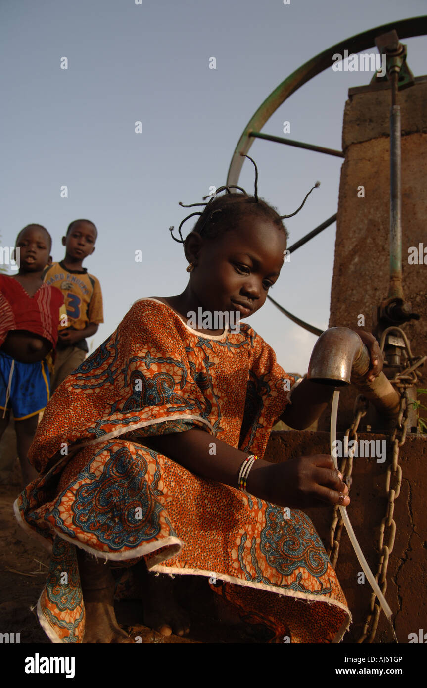 child plays with water at well in West Africa Stock Photo - Alamy
