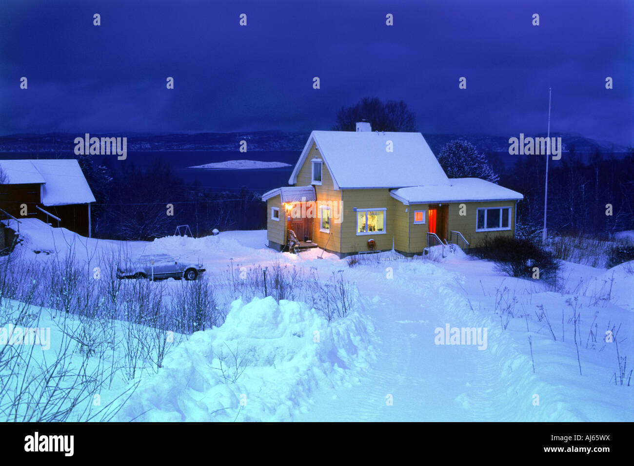 Evening lights from snowbound home on long winter night in Lofoten ...