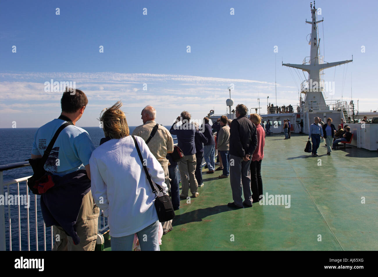 Passengers along railing on deck of P O ferry Pride of Bilbao watching ...