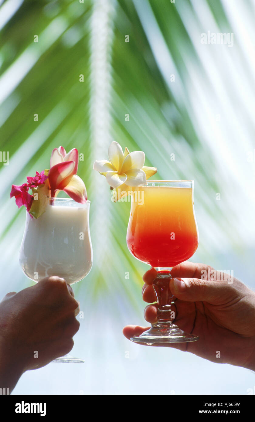 Couple on island holiday toasting with tropical drinks Stock Photo - Alamy