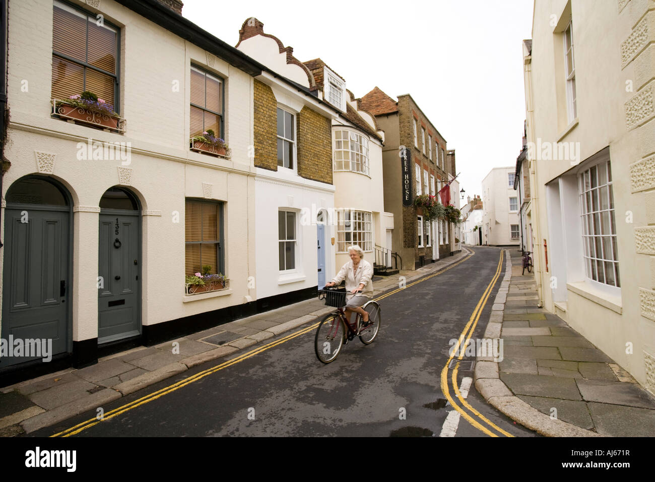 older woUK Kent Deal Old Town Middle Street man cyclist cycling along ...