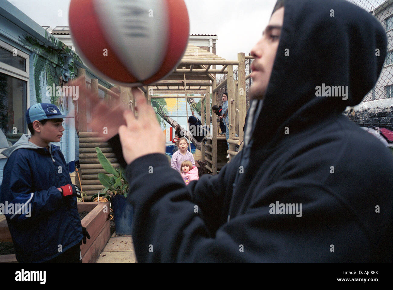 Young man spinning a ball in kids playground Stock Photo - Alamy
