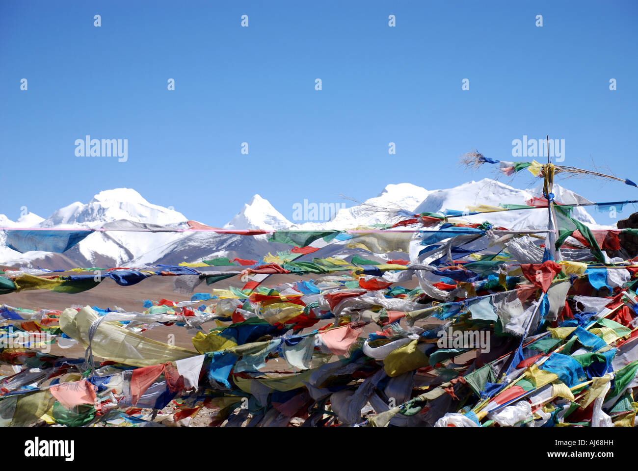Prayer flags frame the vast Himalayan mountain range which is clearly ...