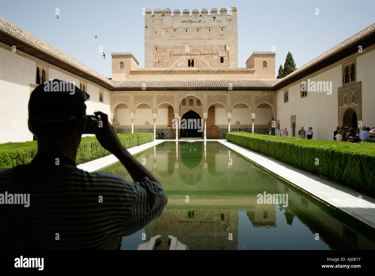 A tourist photographs the reflecting pool in the Patio de los Arrayanes ...