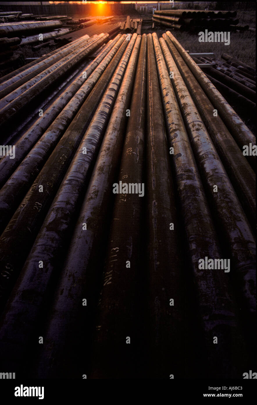Drilling pipe stack with sunset Stock Photo - Alamy