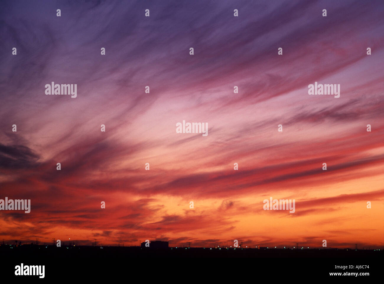 Orange and purple sky with wispy clouds at sunset Stock Photo - Alamy