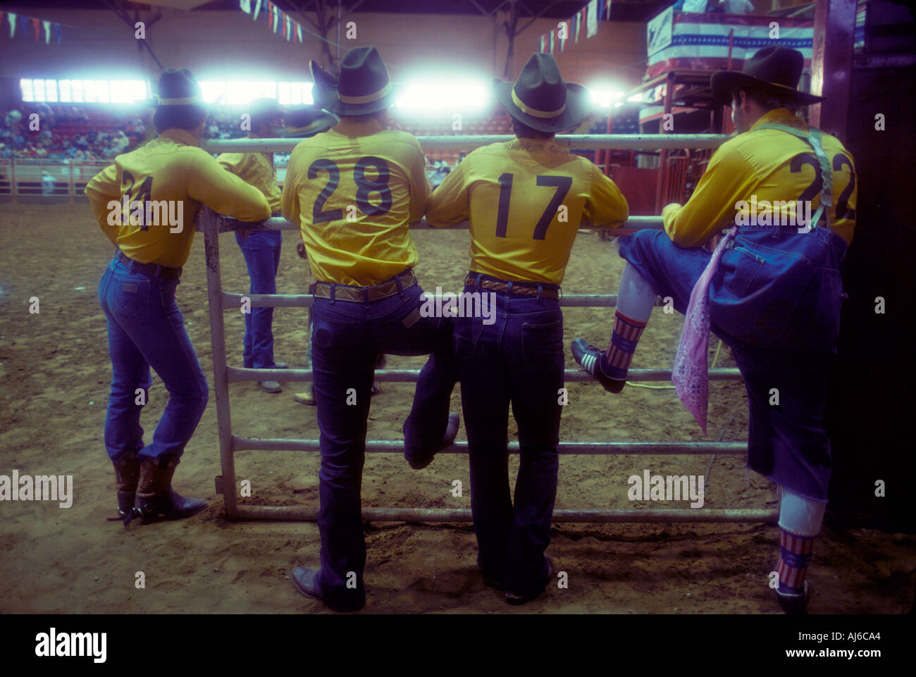 Four cowboys on gate in rodeo arena Stock Photo - Alamy