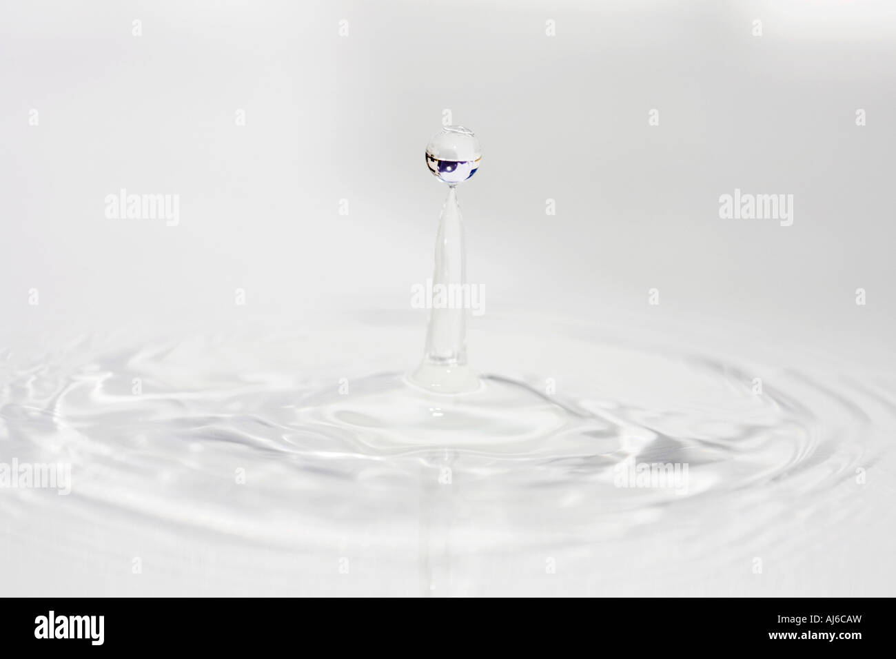 Water drop on white water mirrored surface Stock Photo - Alamy