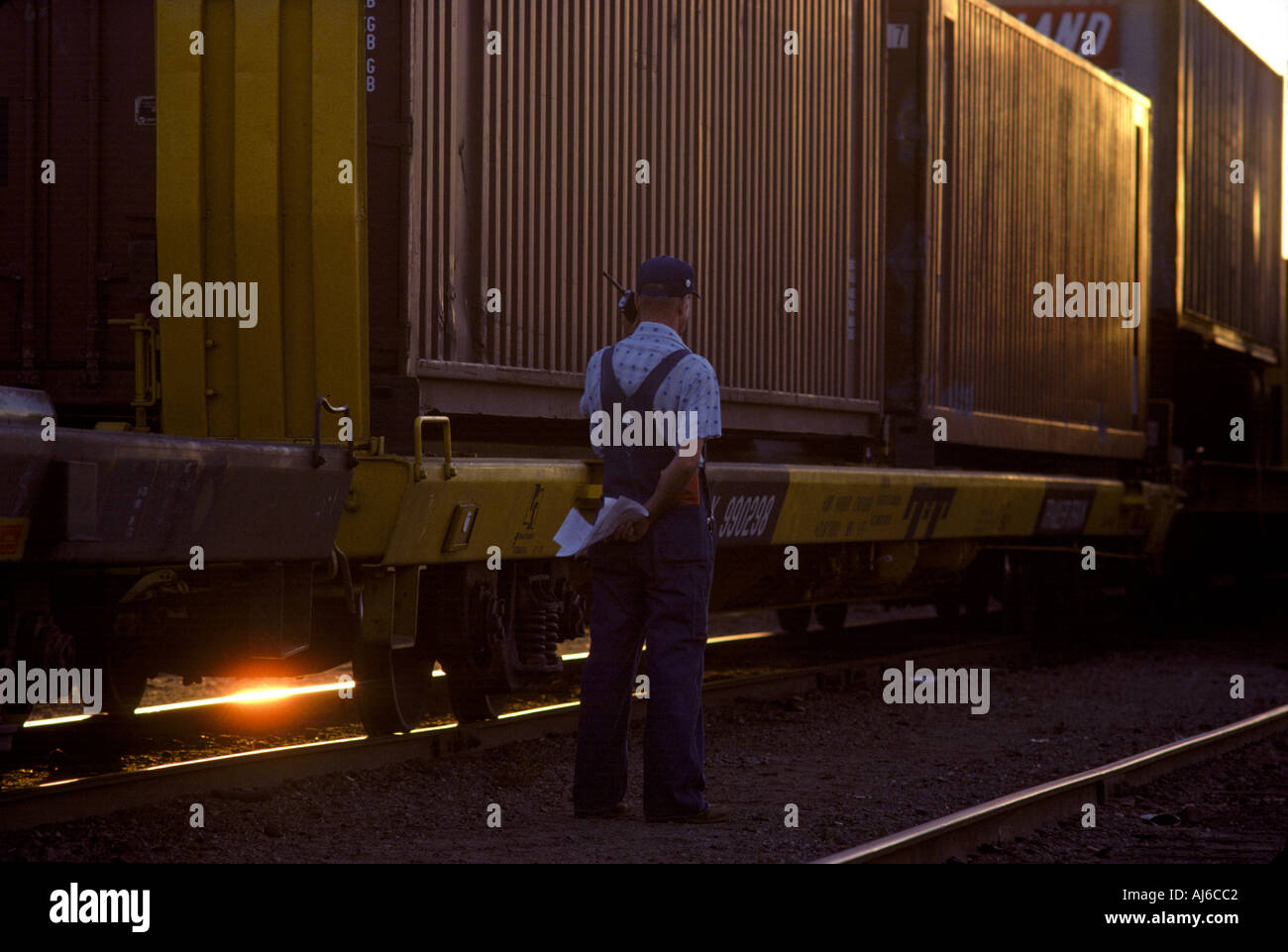 Railroad worker on walkie talkie in train yard Stock Photo - Alamy