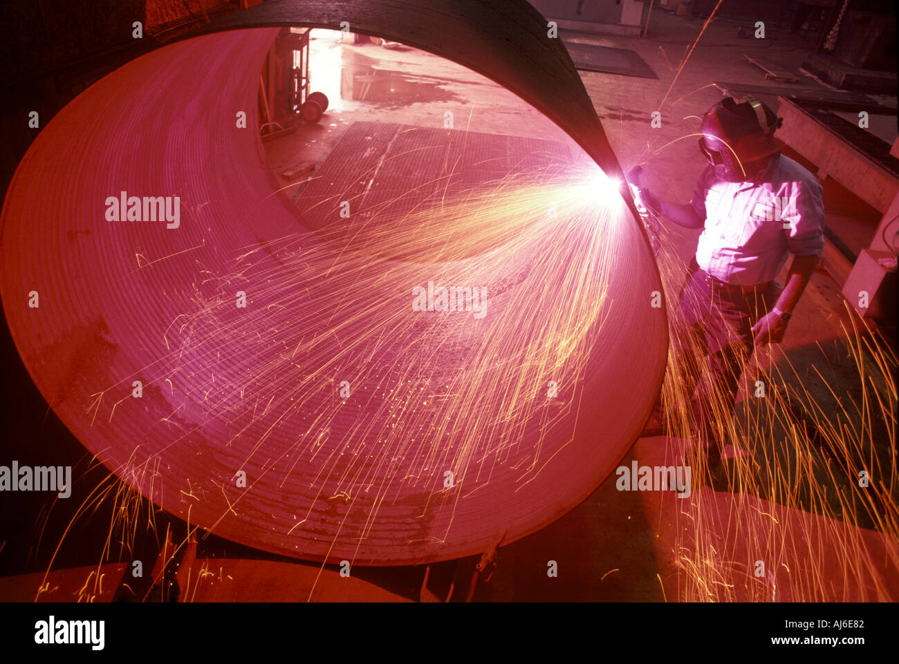 Welder cutting large metal tube or pipe Stock Photo - Alamy