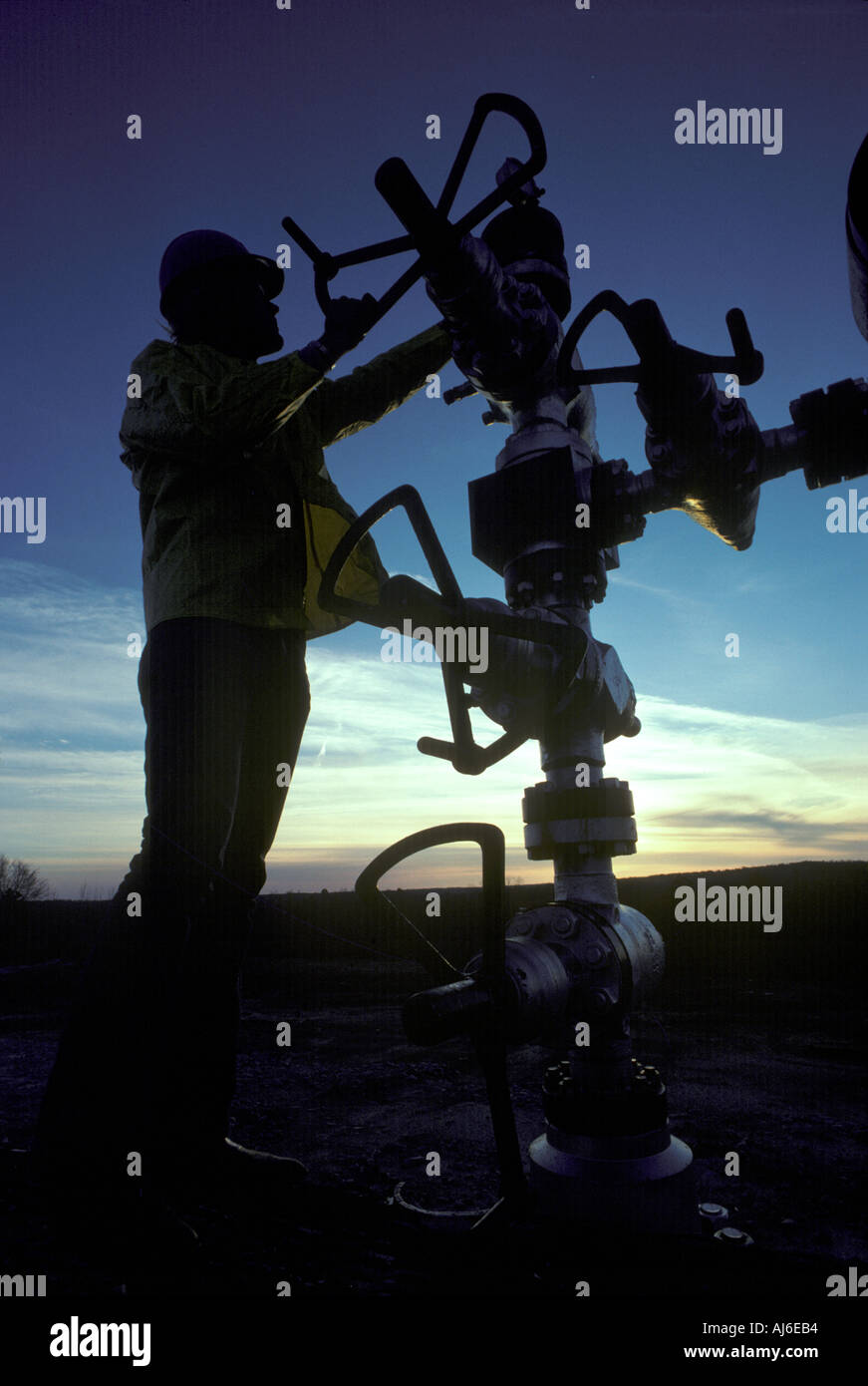 Worker operating valves on oil or gas well Christmas Tree Stock Photo ...