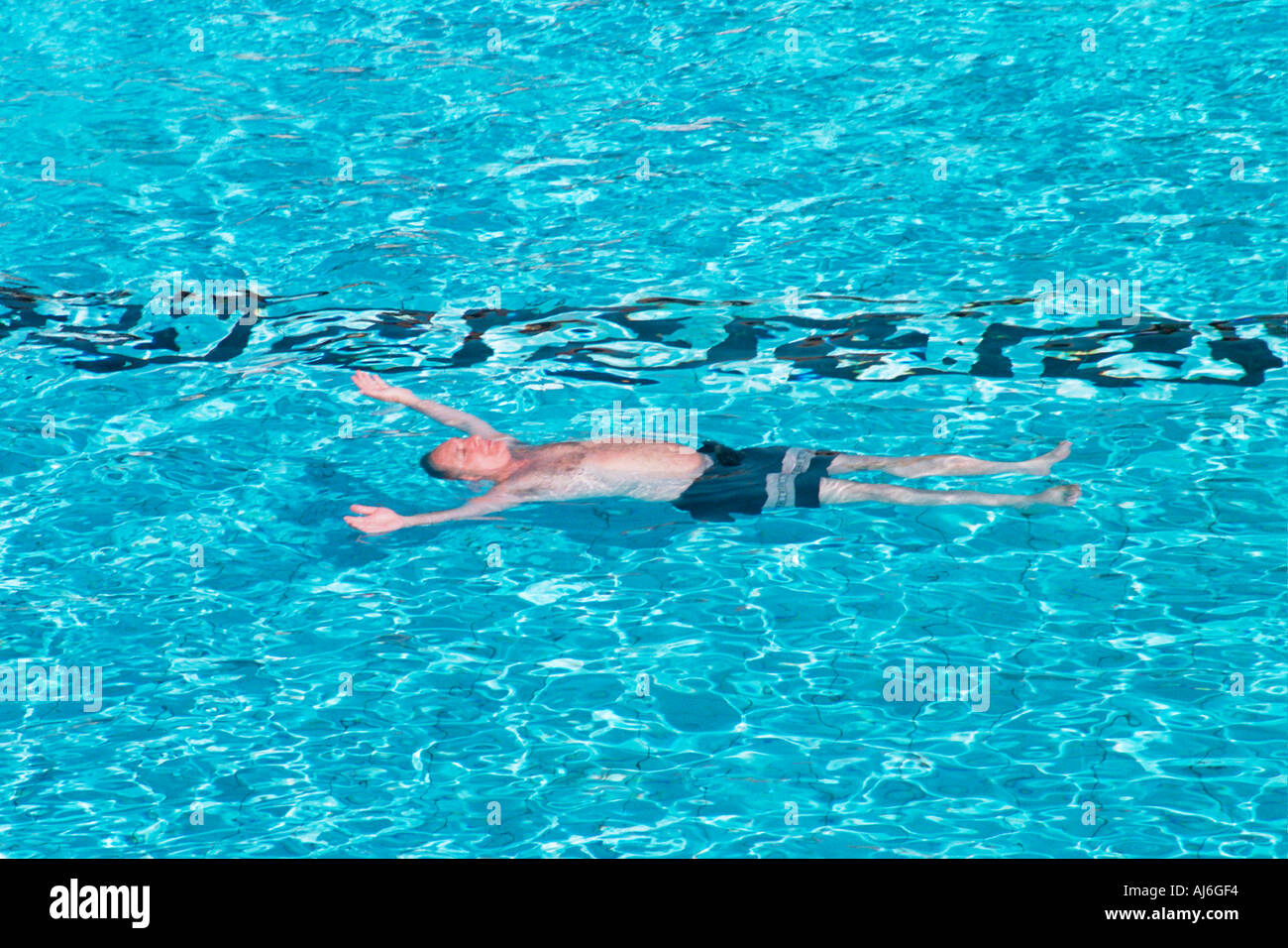 A man floating on his back in a swimming pool Stock Photo - Alamy