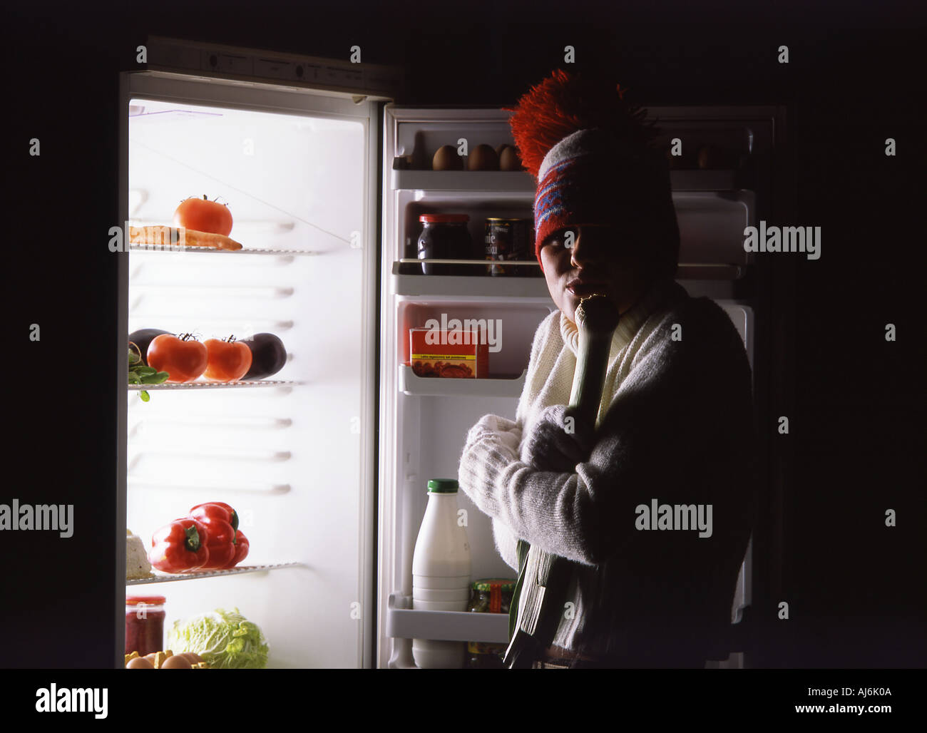 Young woman looking into the fridge at night Stock Photo - Alamy