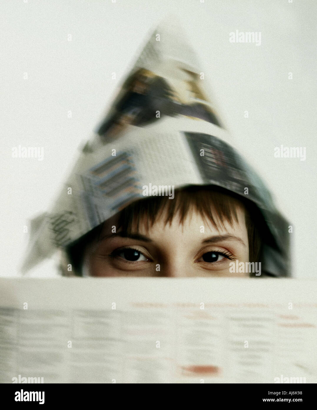 Young woman wearing a newspaper hat Stock Photo - Alamy