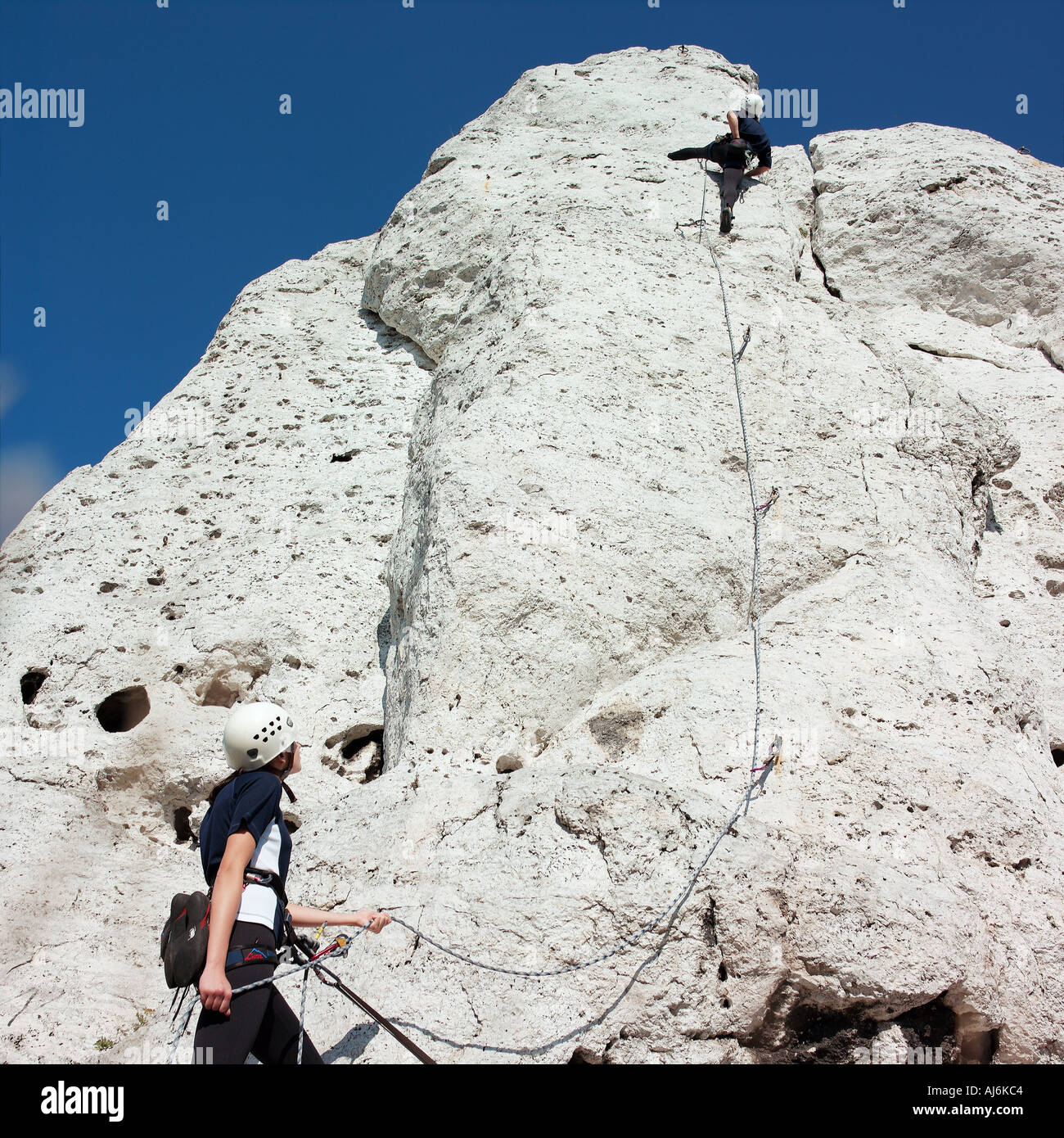 Two people climbing mountain Stock Photo - Alamy