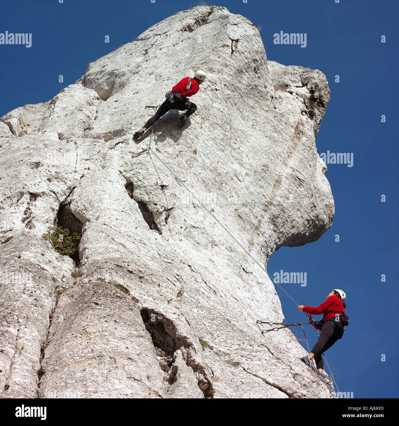 Two people climbing mountain Stock Photo - Alamy