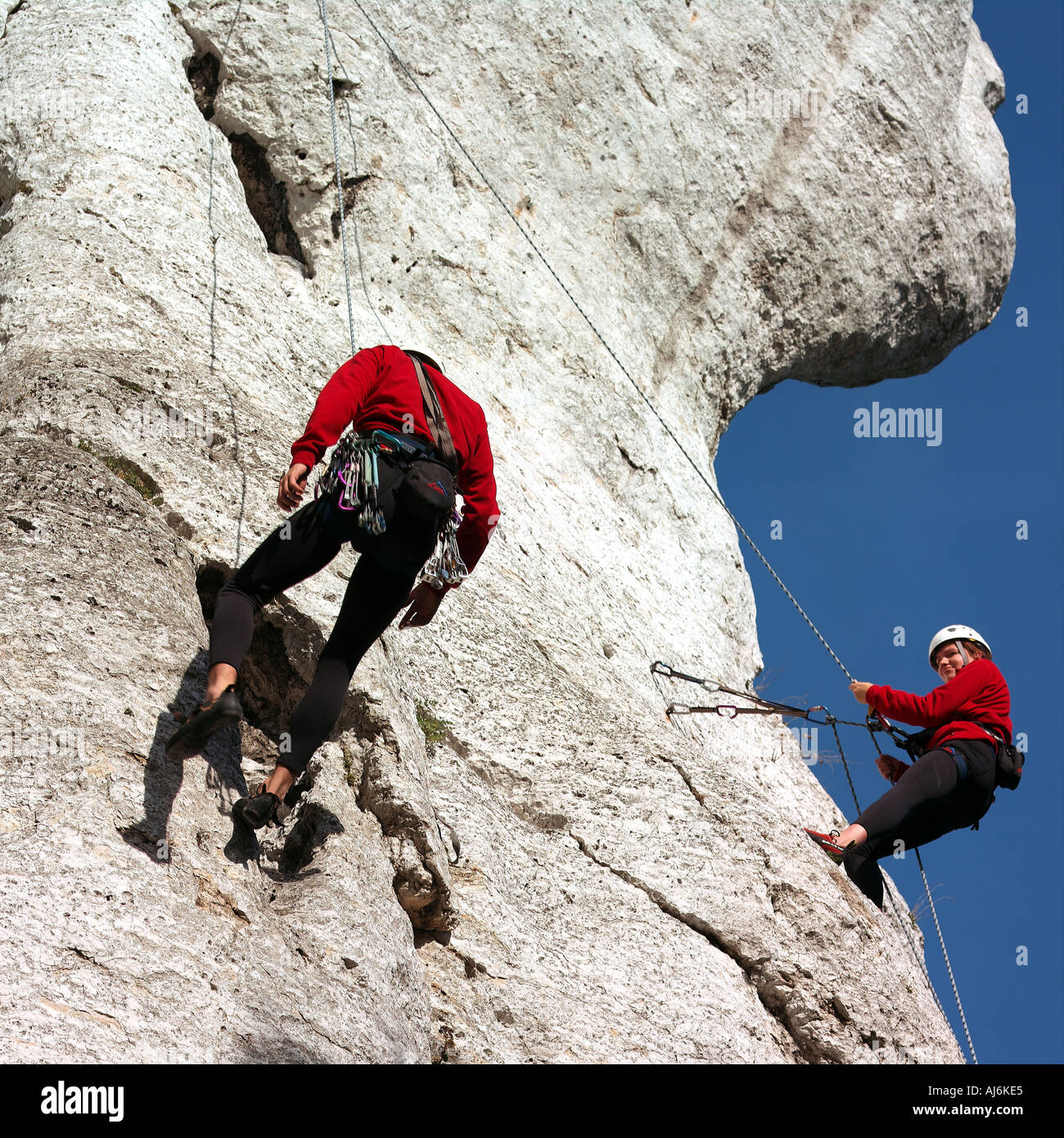 Two people climbing mountain Stock Photo - Alamy
