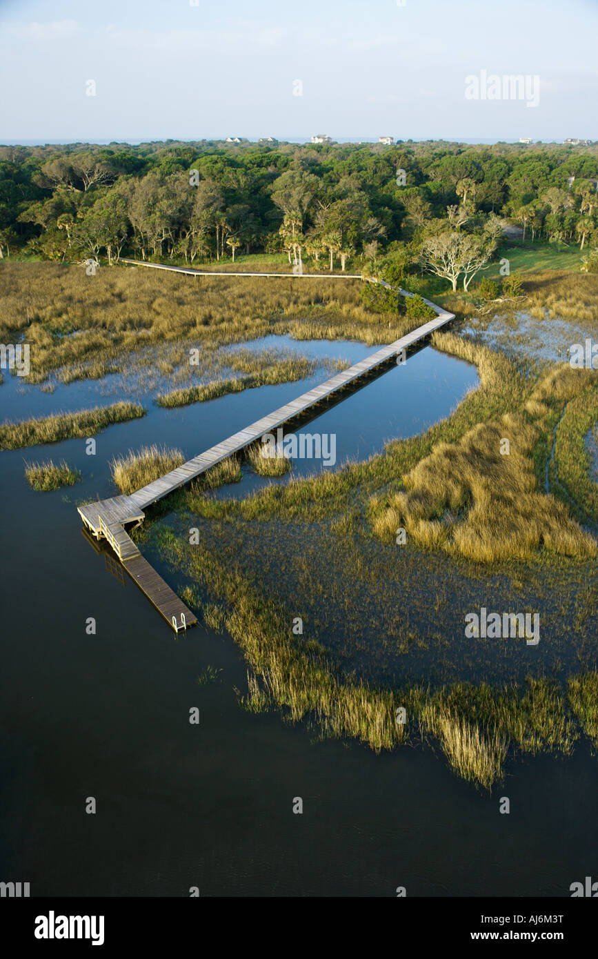 Aerial view of dock and boardwalk stretching over coastal marsh area on ...
