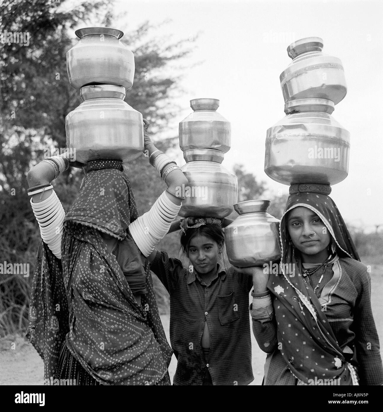 Three women with their water pots Stock Photo - Alamy