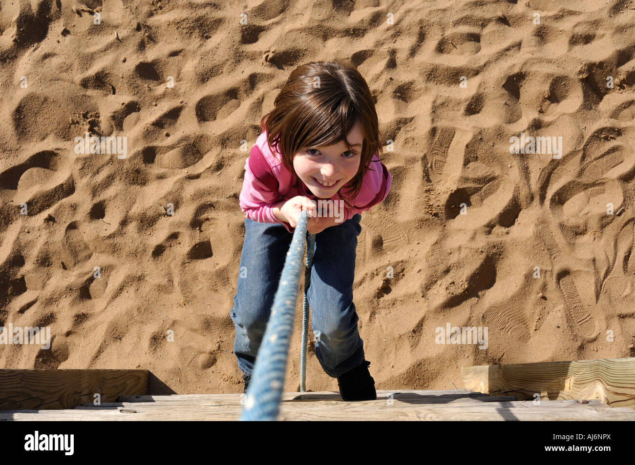 Young girl age 9 climbing up a rope at a playground Stock Photo - Alamy