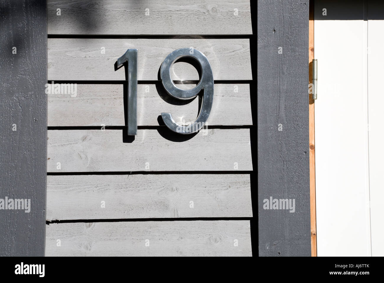 Number nineteen on a grey clapboard Swedish house front door Stock ...
