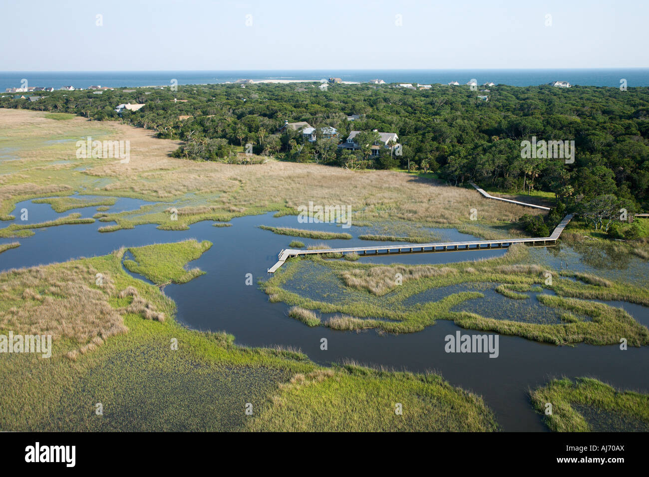 Aerial of marsh with dock and pier and houses in background in Bald ...