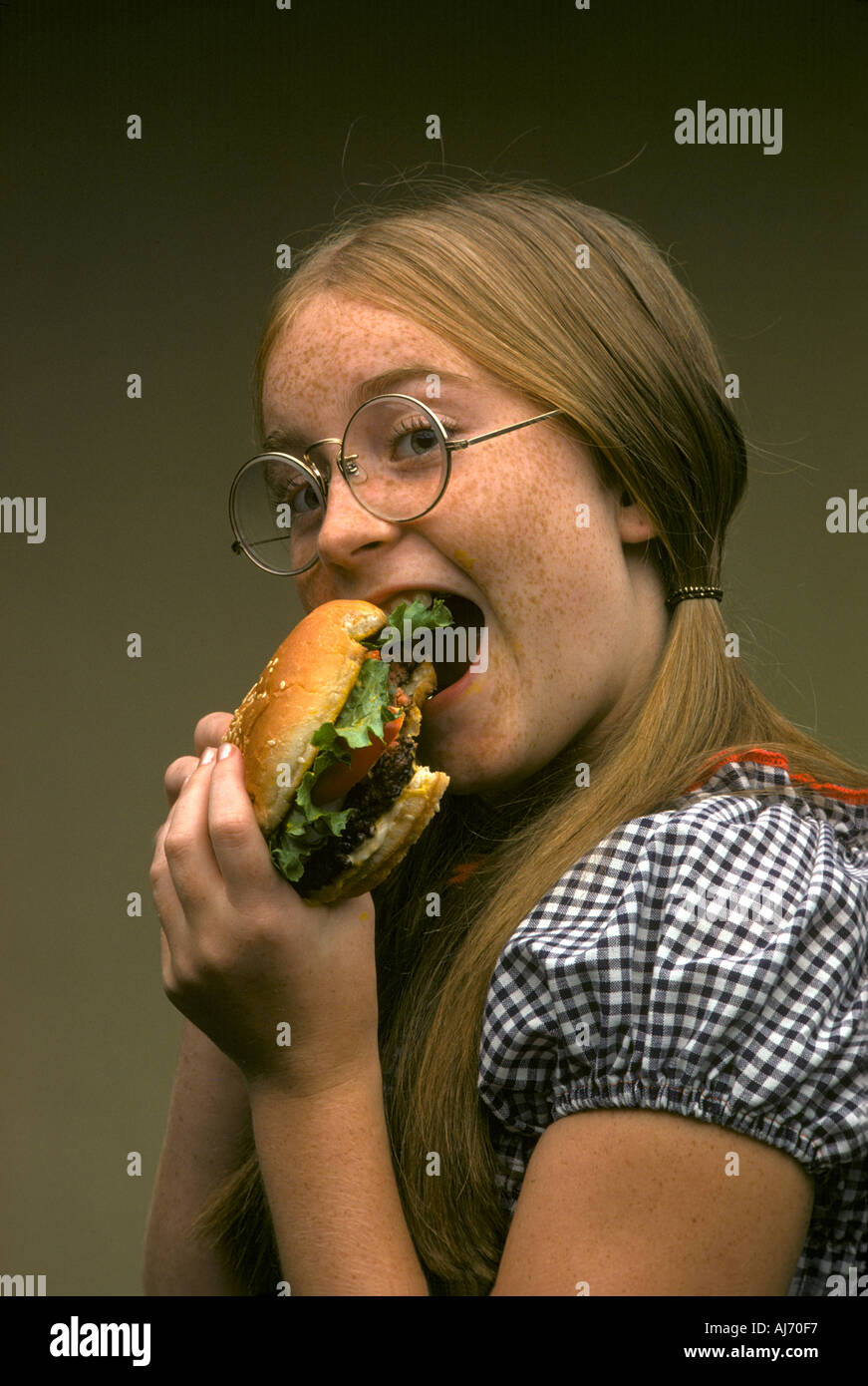 Young girl eating hamburger Stock Photo - Alamy