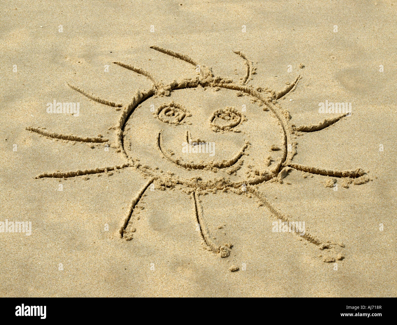 drawing of sun on sand on beach Stock Photo - Alamy