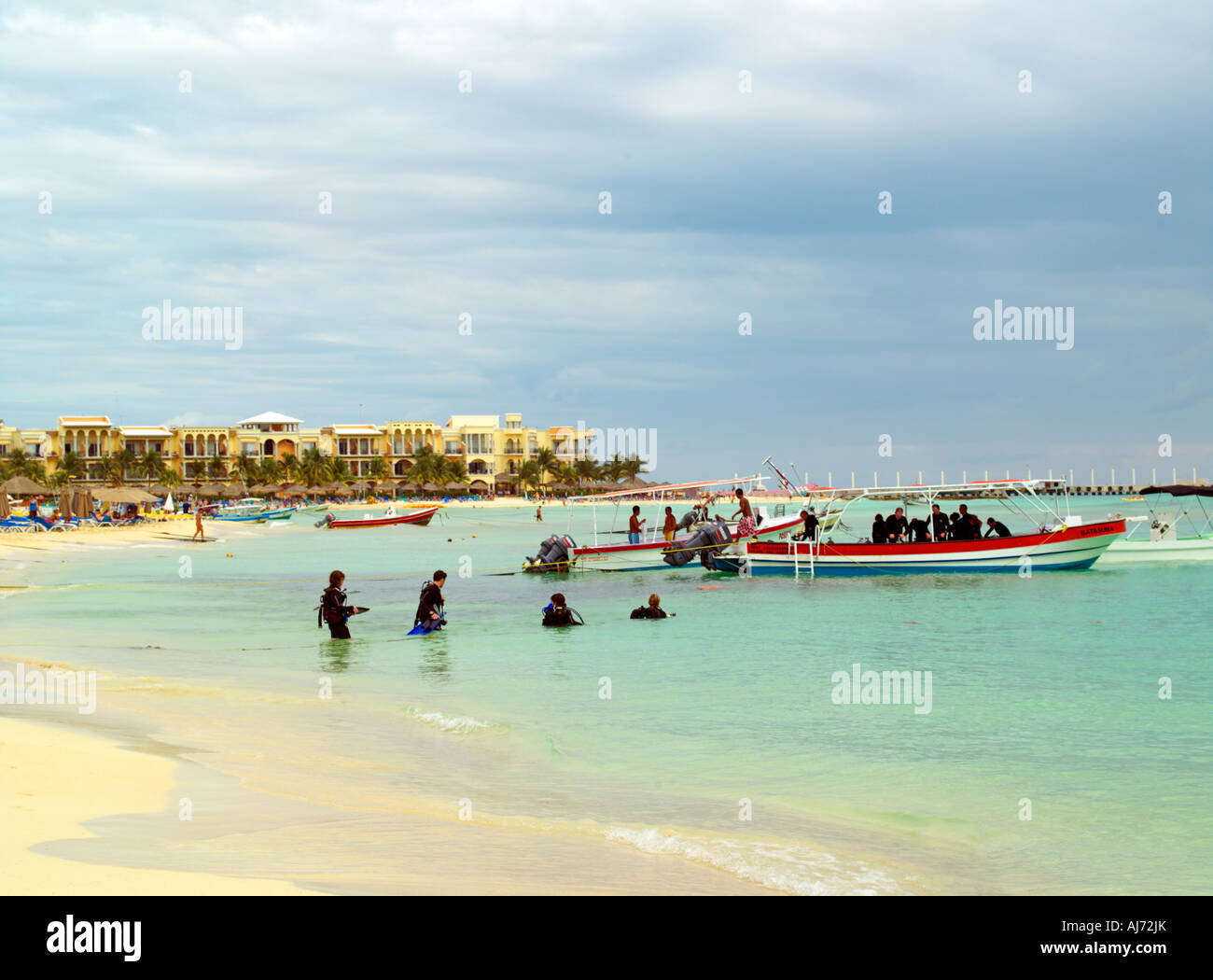 A group of divers wading out to their boat moored on the beach at Playa ...