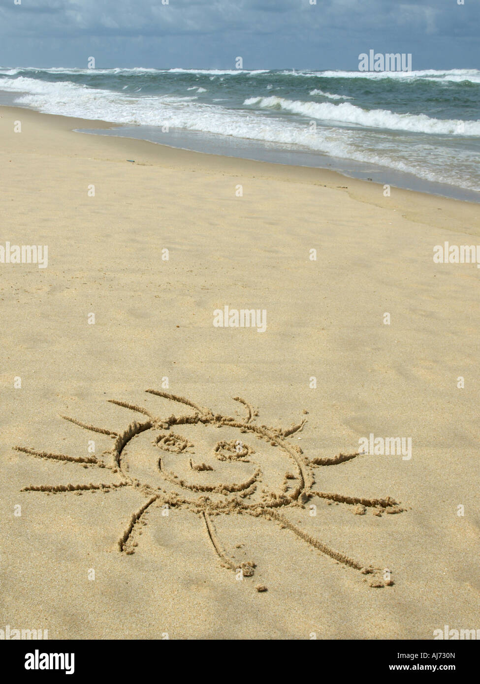 drawing of sun on sand on beach Stock Photo - Alamy