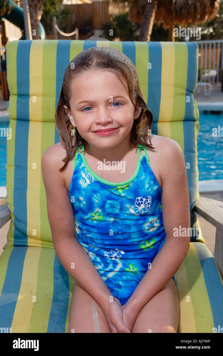 Young girl sitting pool side Stock Photo - Alamy