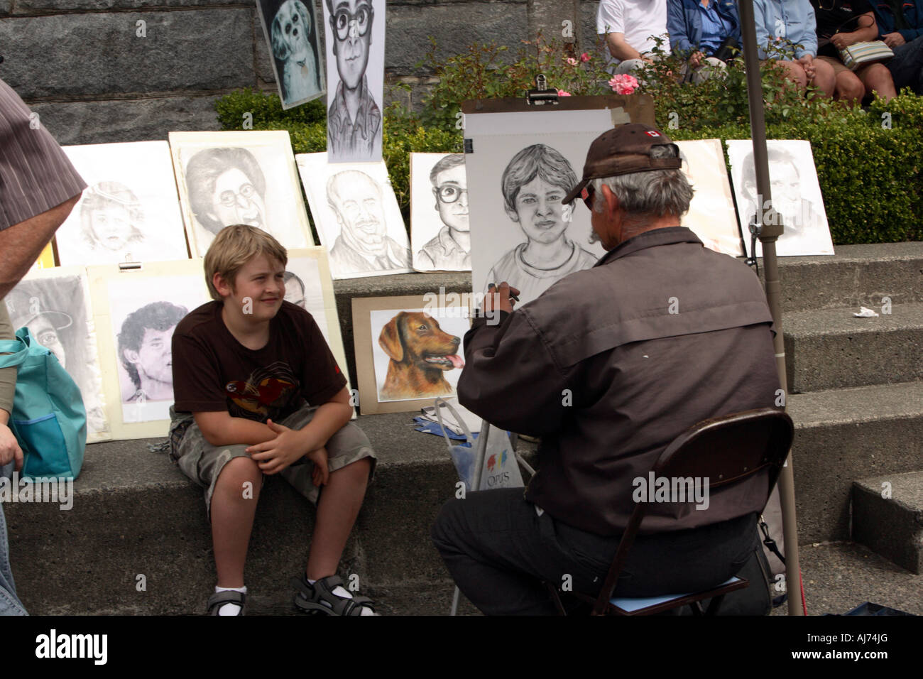 Artist drawing a portrait of a boy in downtown Victoria during Canada ...