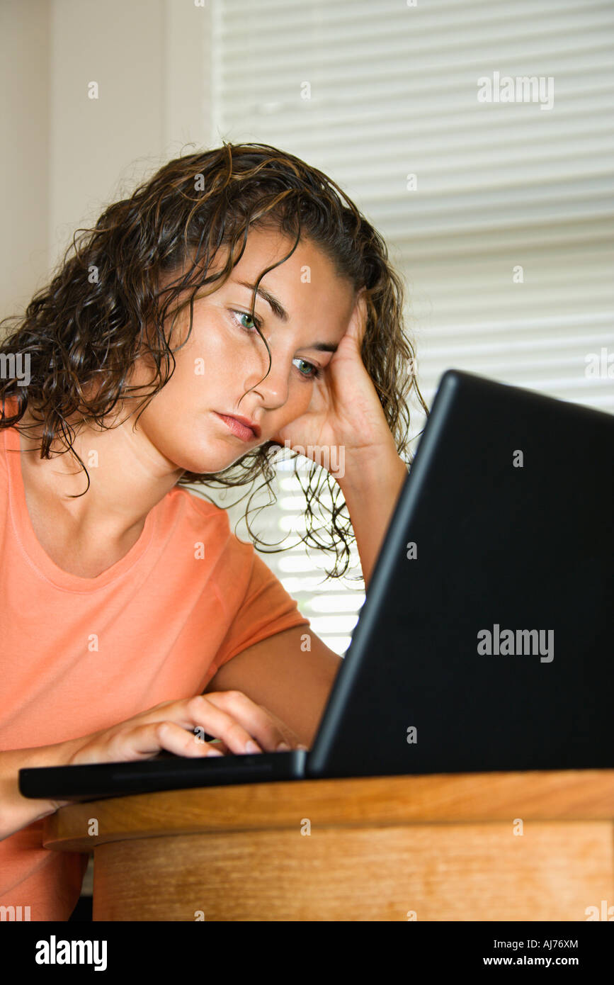 Pretty young adult Caucasian brunette woman sitting and working on ...