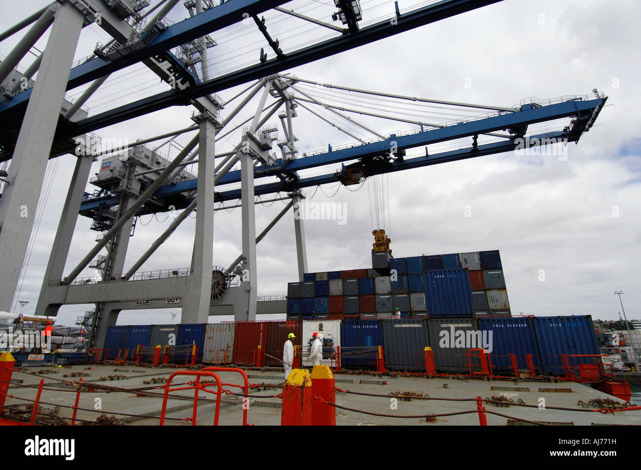Shipping containers being loaded on to the deck of a container ship by ...