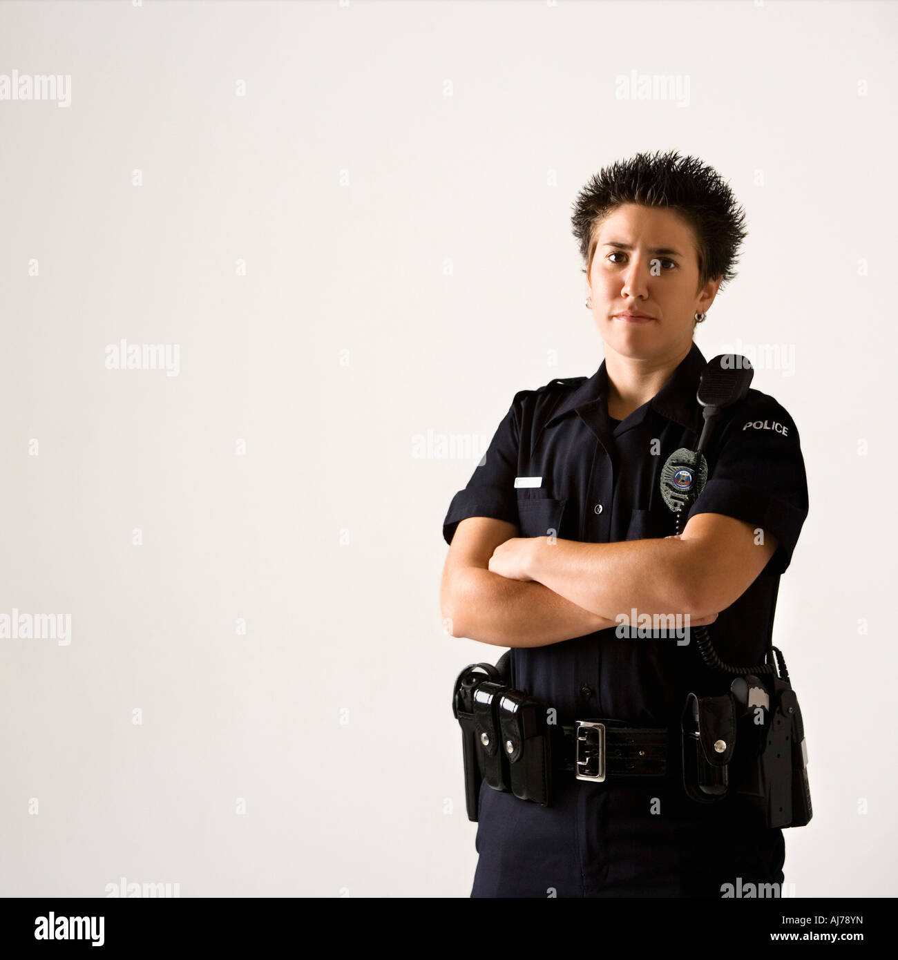 Portrait of mid adult Caucasian policewoman standing with hand on gun ...