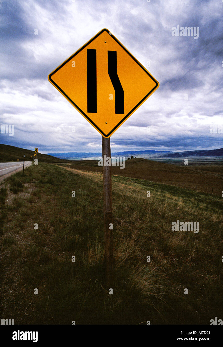 Merge to one lane road sign with clouds Stock Photo - Alamy