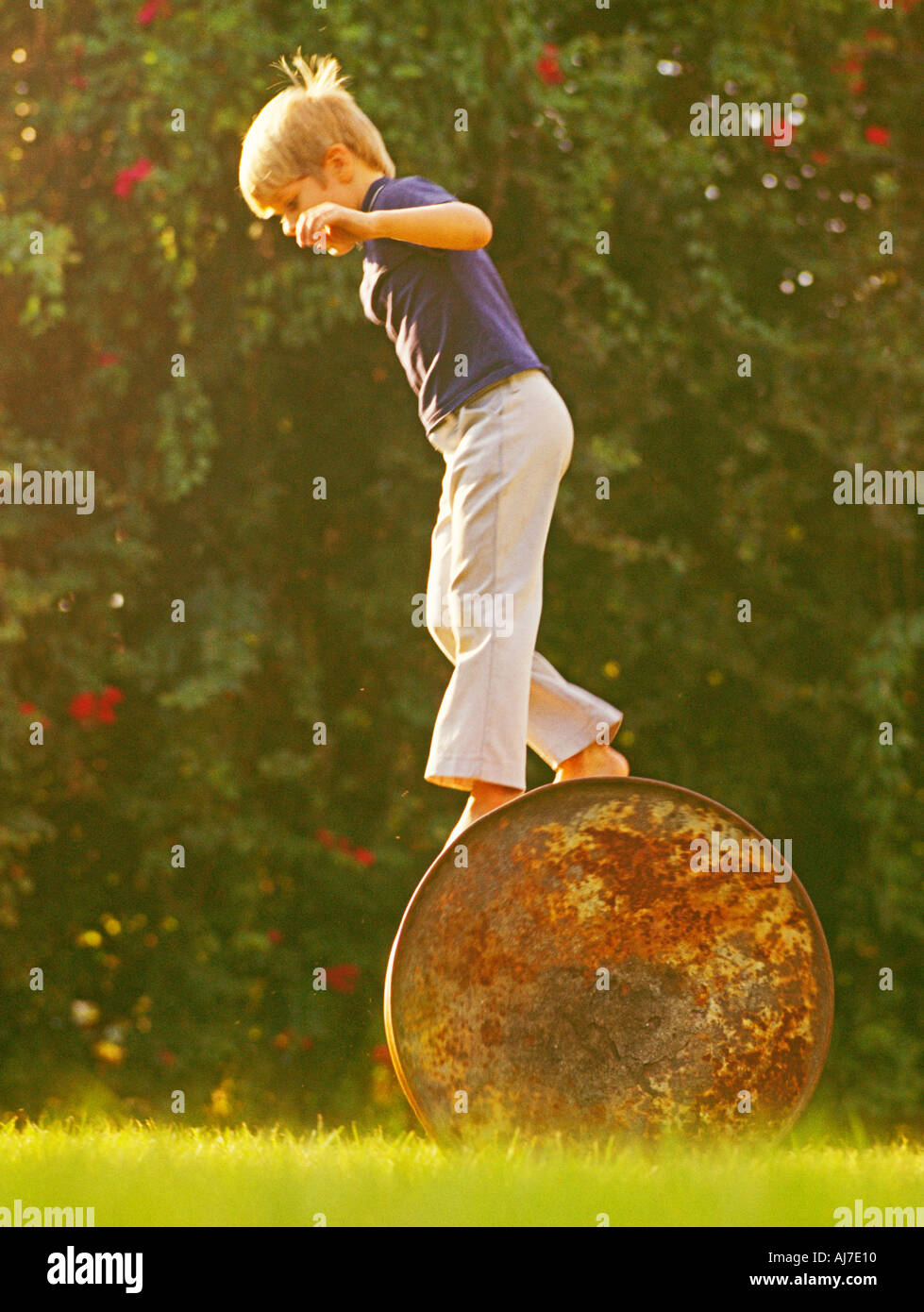young boy balancing on large 55 gallon oil drum Stock Photo - Alamy