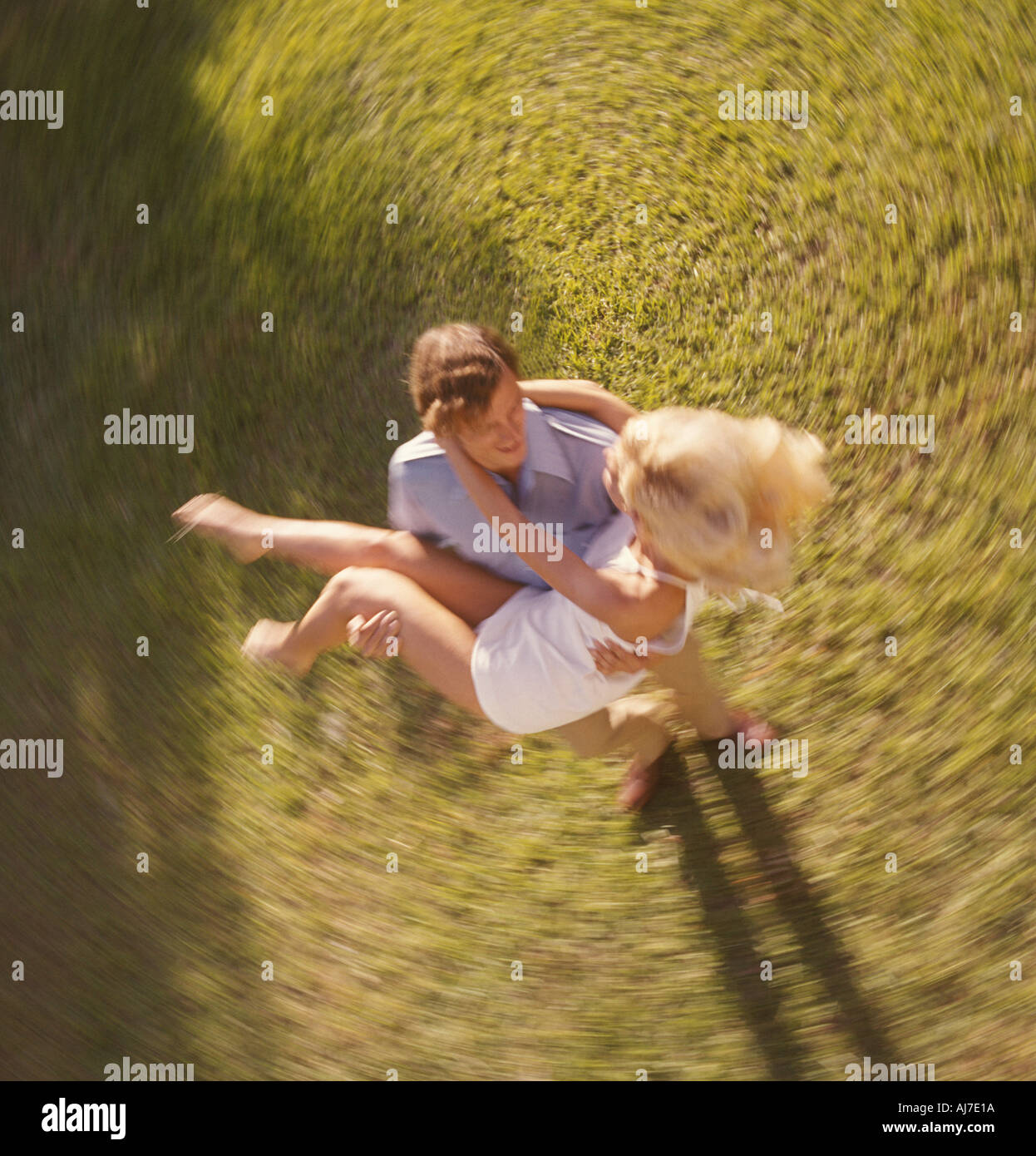 young couple whirling around on lawn Stock Photo - Alamy