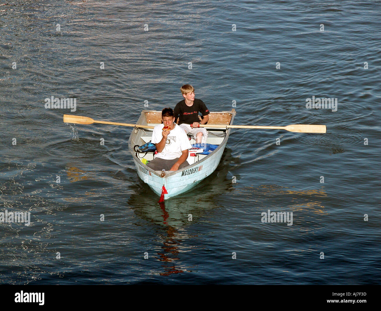 Two Male Teens in a Row Boat Stock Photo - Alamy