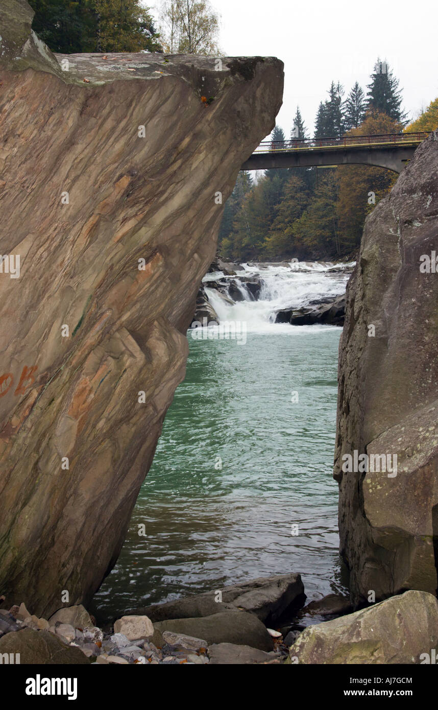 Autumn mountain river viev through chink between two big rocks with ...