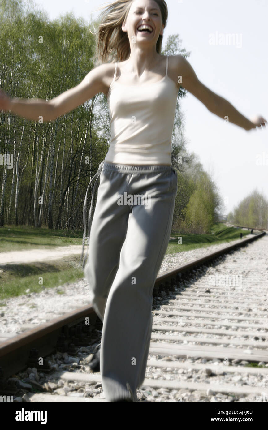 Woman running on railroad tracks Stock Photo - Alamy