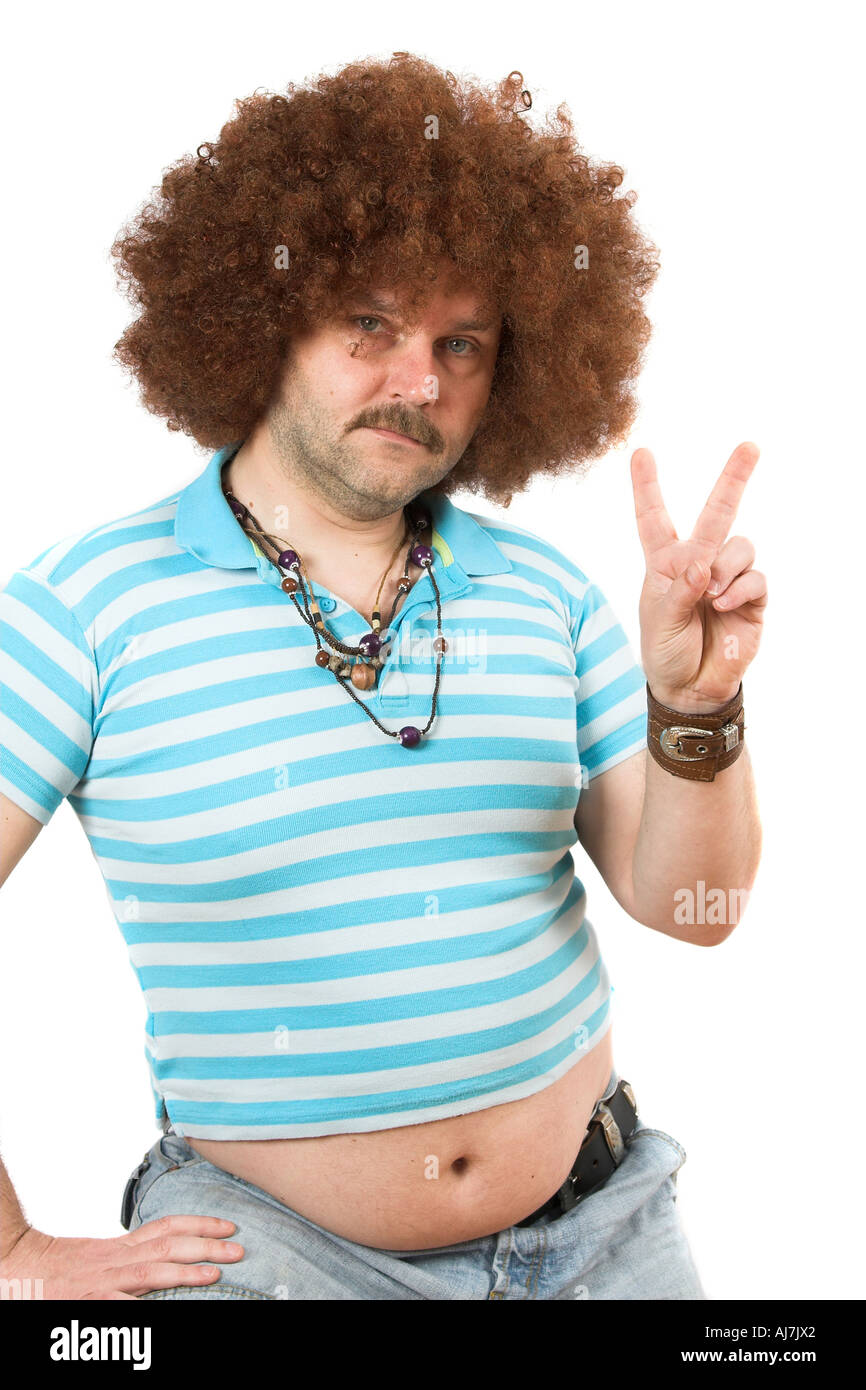 Old hippie with beerbelly hanging over his jeans making the peace sign ...