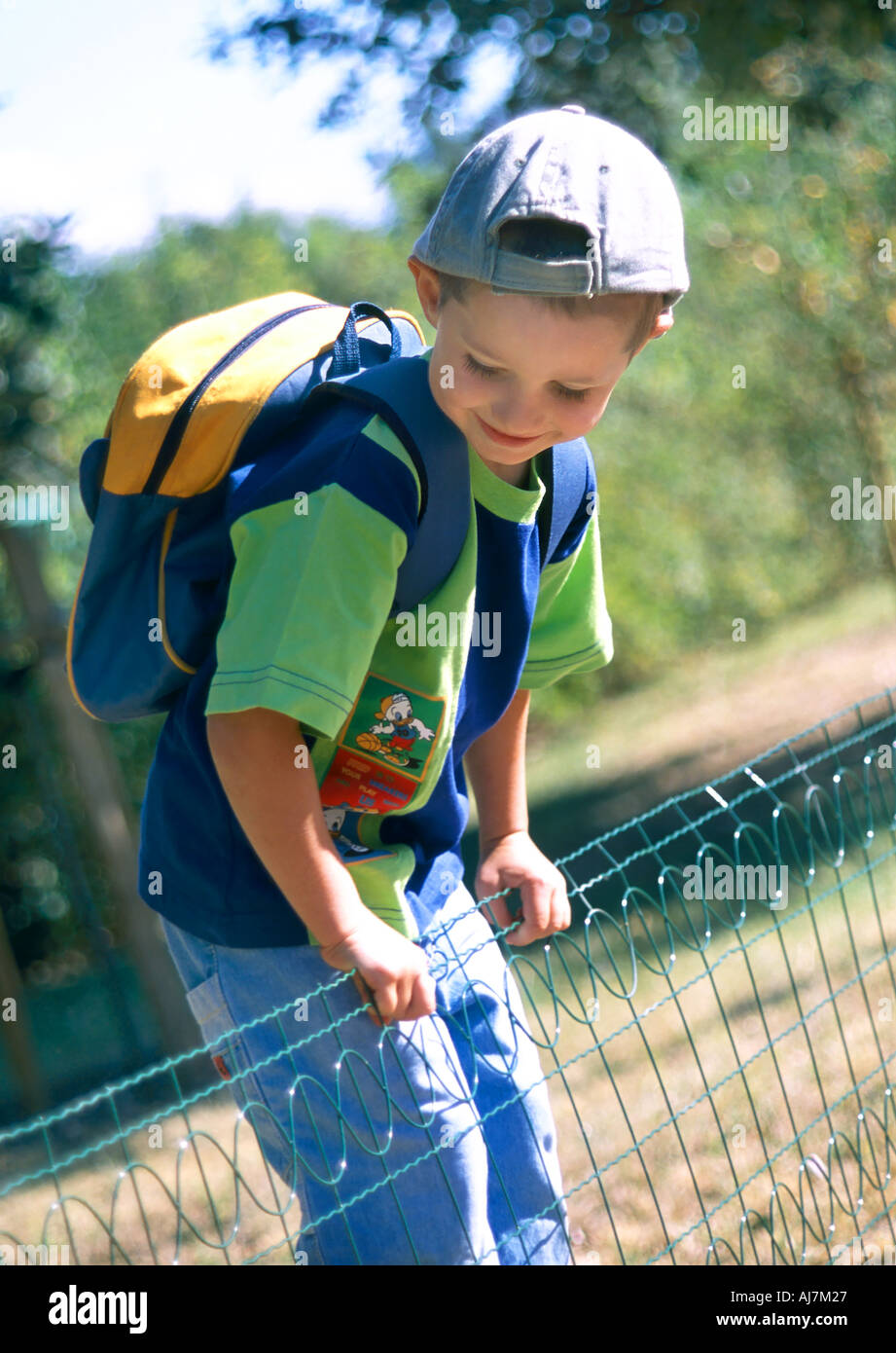 child boy schoolboy smile smiling knapsack cap passage passing barrier ...
